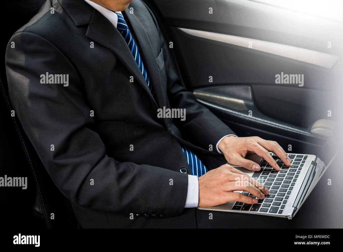 Handsome Young businessman using laptop and sitting in back seat of car Stock Photo - Alamy