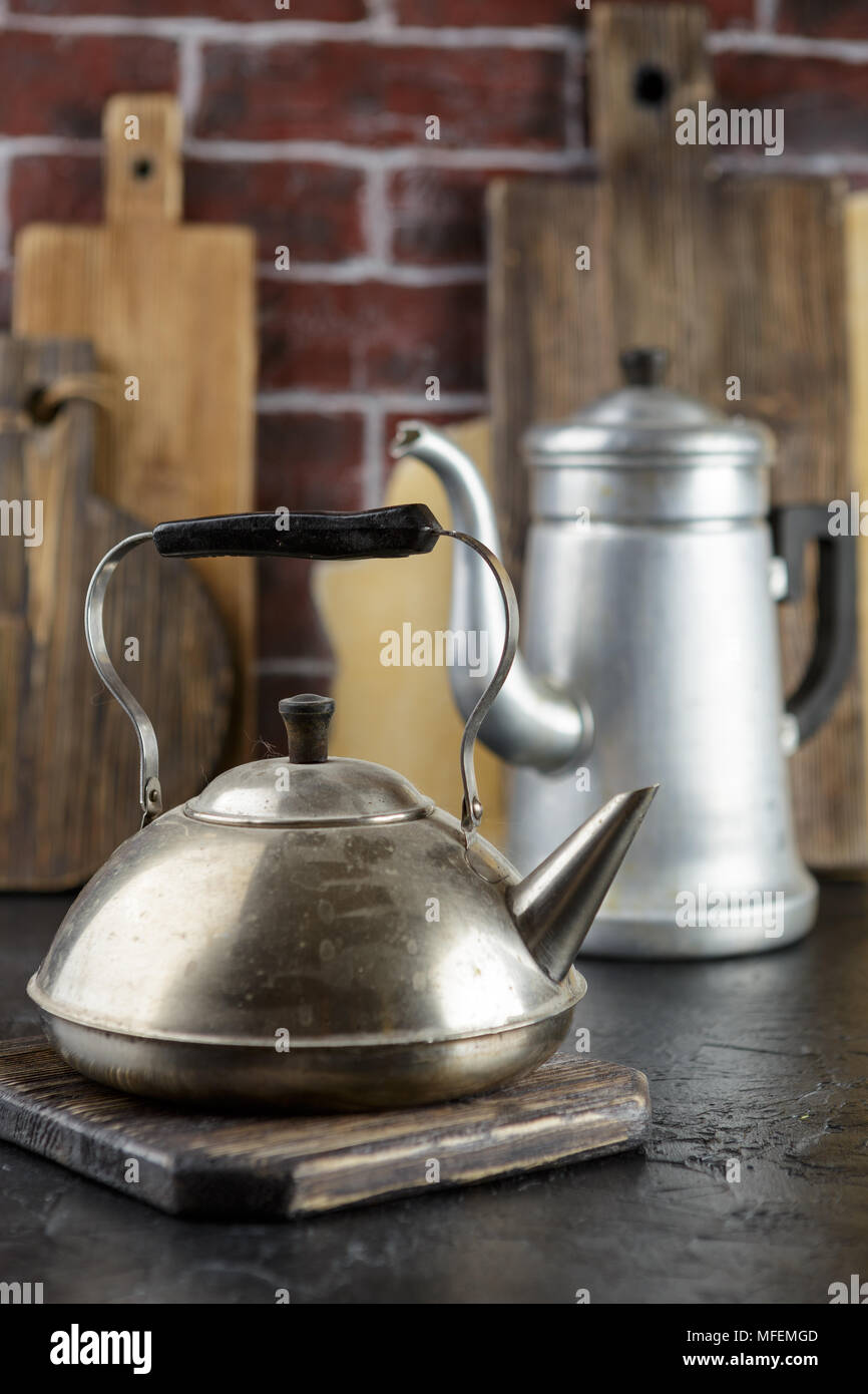 Old metal kettle and coffee pot on a brick wall background Stock Photo ...