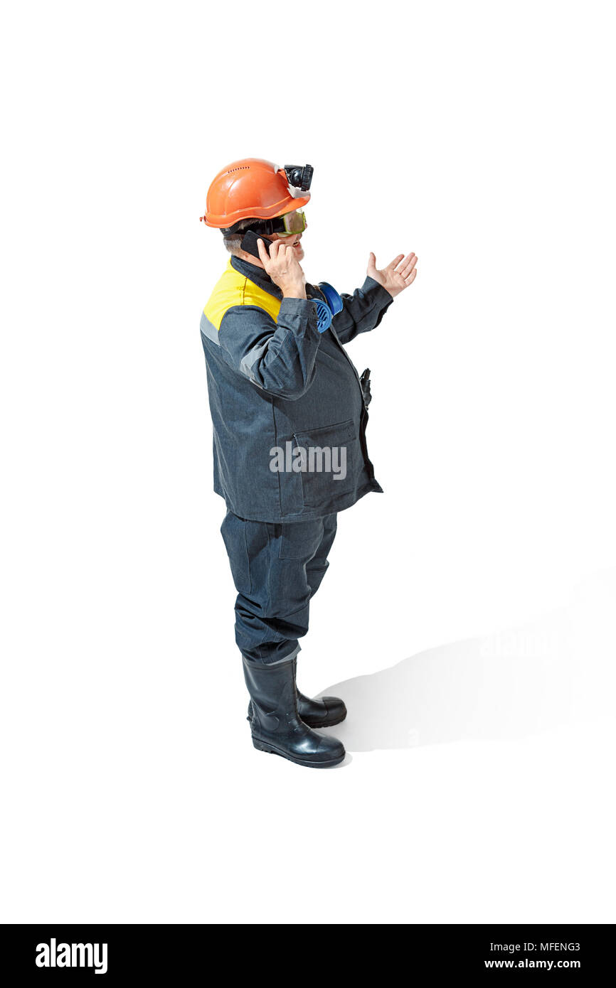 The studio shot of senior bearded male miner standing at the camera on ...