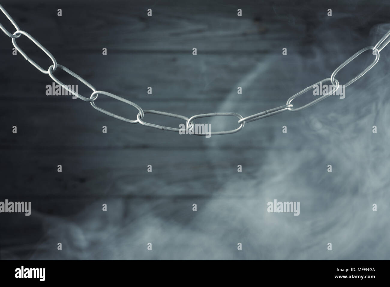 Old iron chain on a blue wooden background and smoke Stock Photo - Alamy