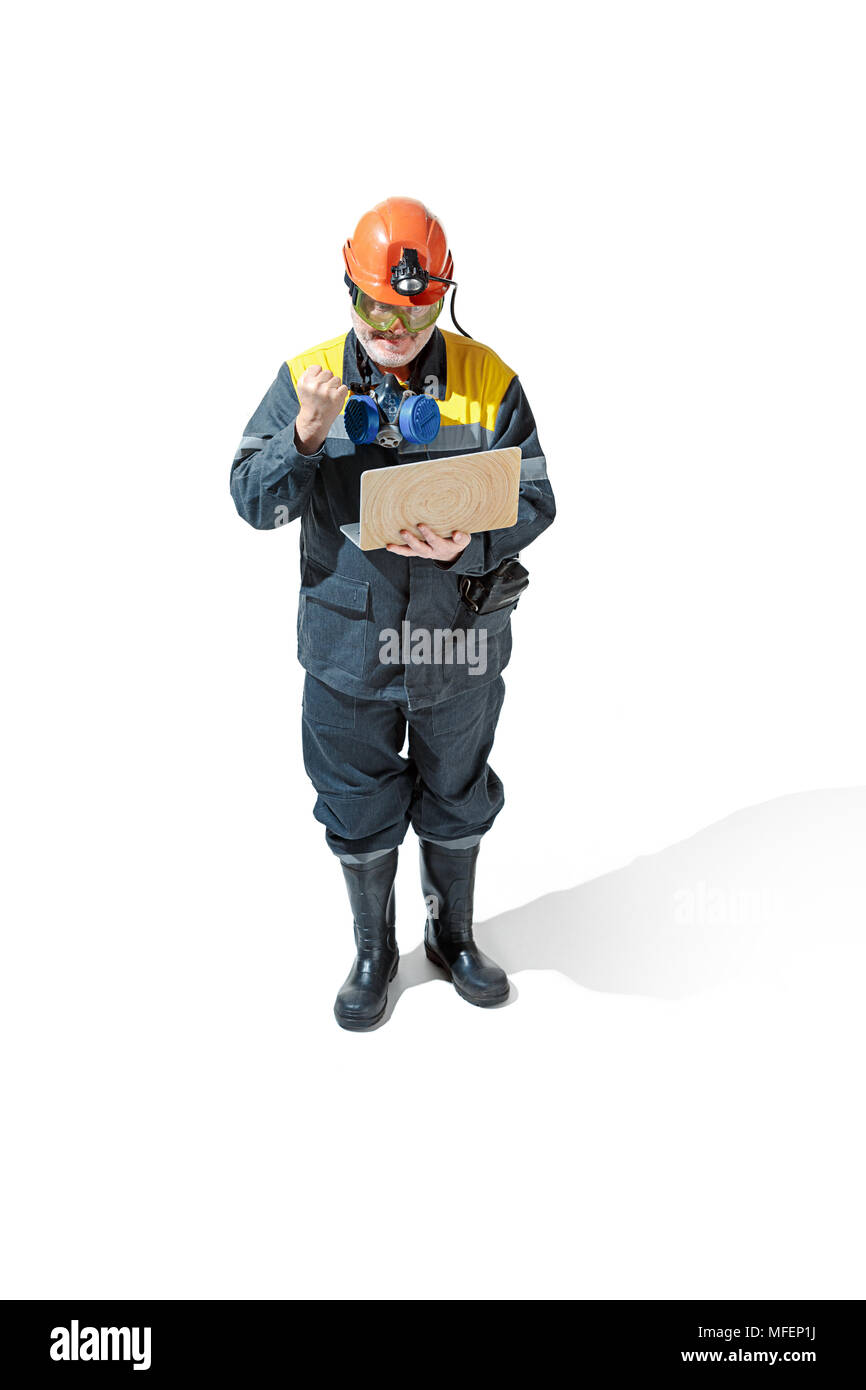 The studio shot of senior bearded male miner standing at the camera on ...