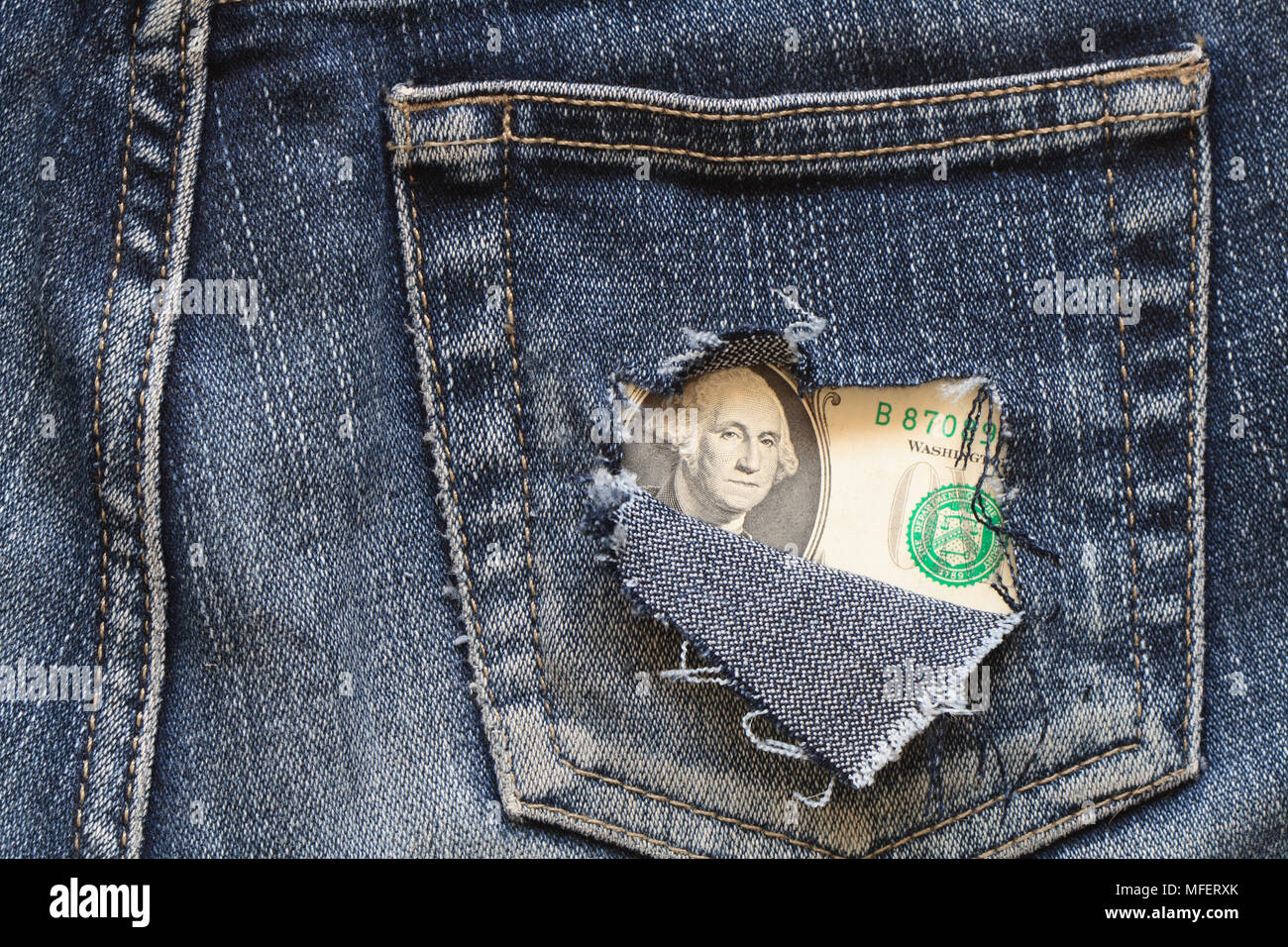 One dollar note inside hole in old jeans pocket Stock Photo - Alamy