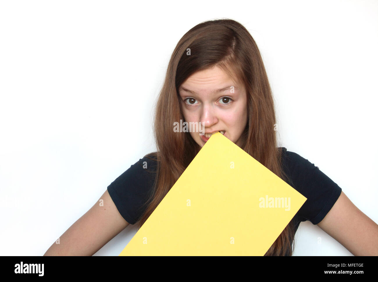 Nice young angry girl holding empty yellow paper board in her mouth ...