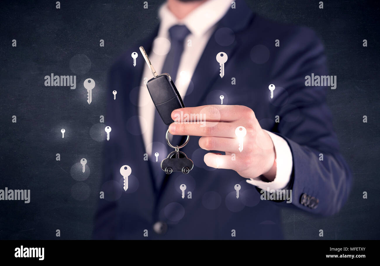 Businessman in suit holding keys with keys graphics around and dark ...