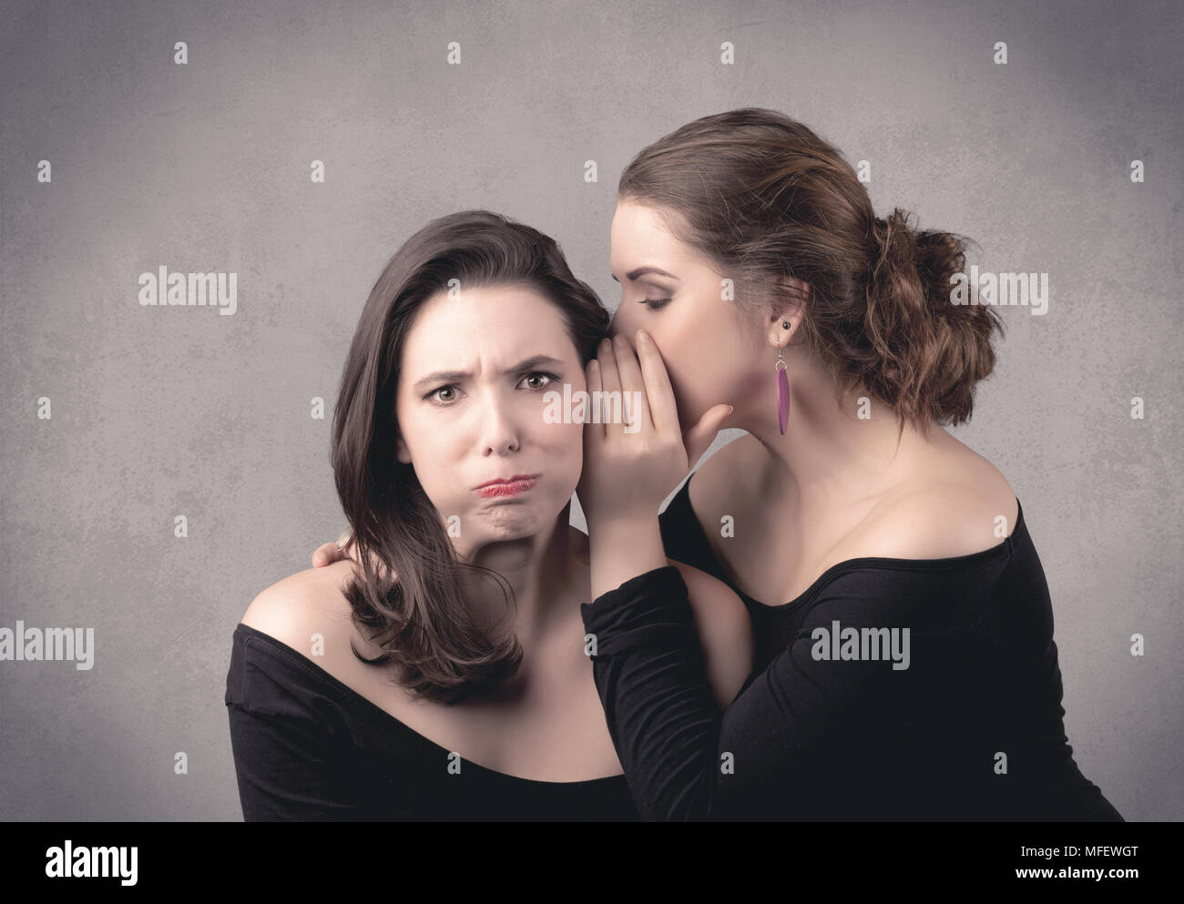 Two fancy dressed actress girls with long hair and make up whispering ...