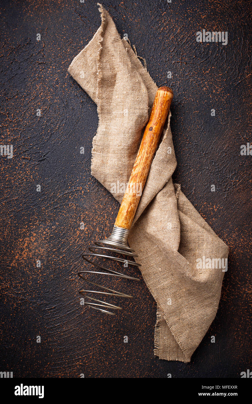Vintage wooden whisk on old rusty background Stock Photo - Alamy