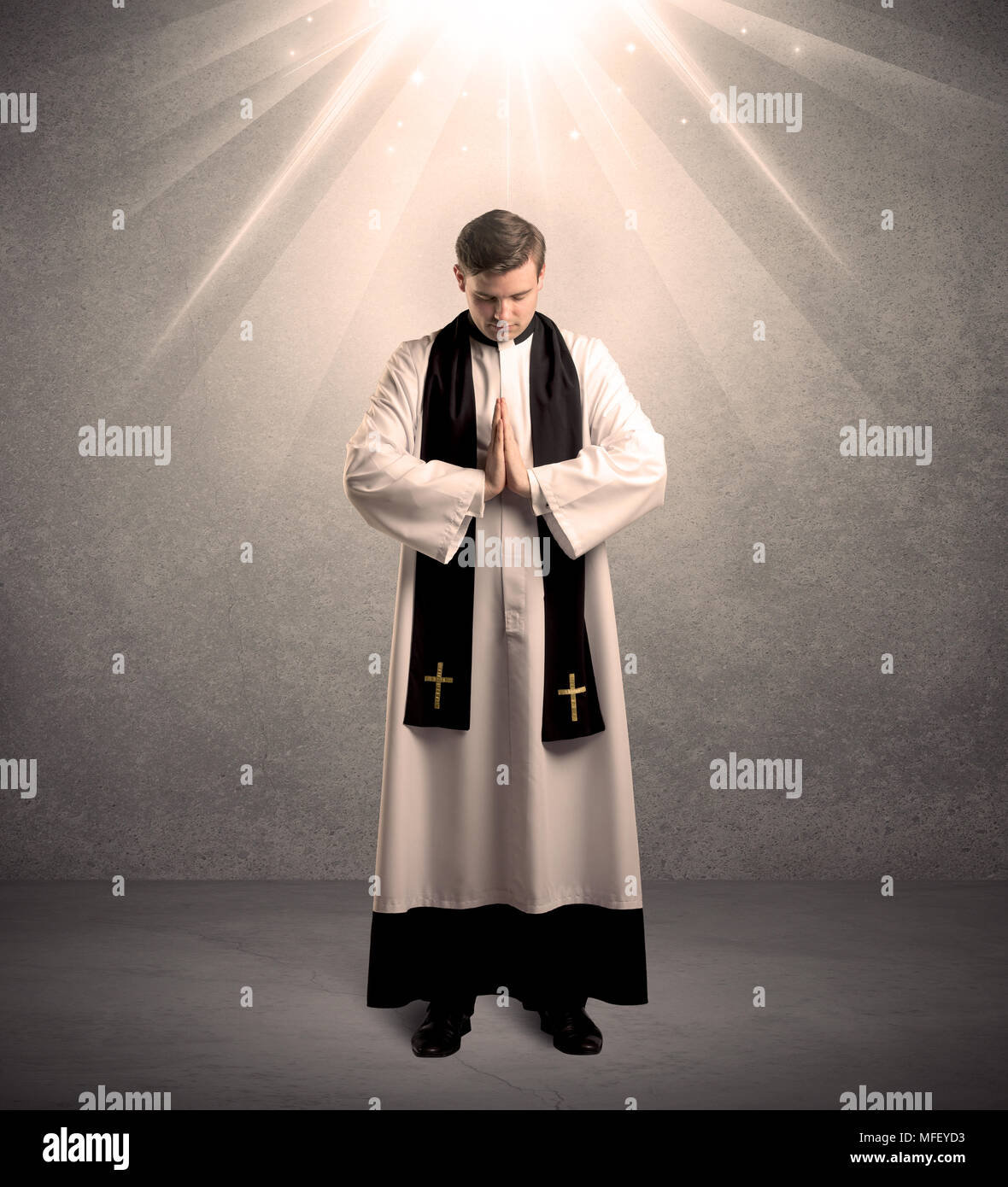 A male religious young priest in black and white dress giving his ...