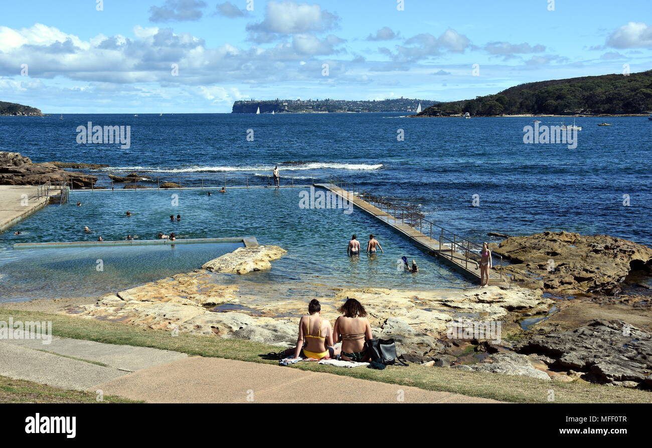 Fairlight beach on a sunny day in summer. People enjoy the cool water ...