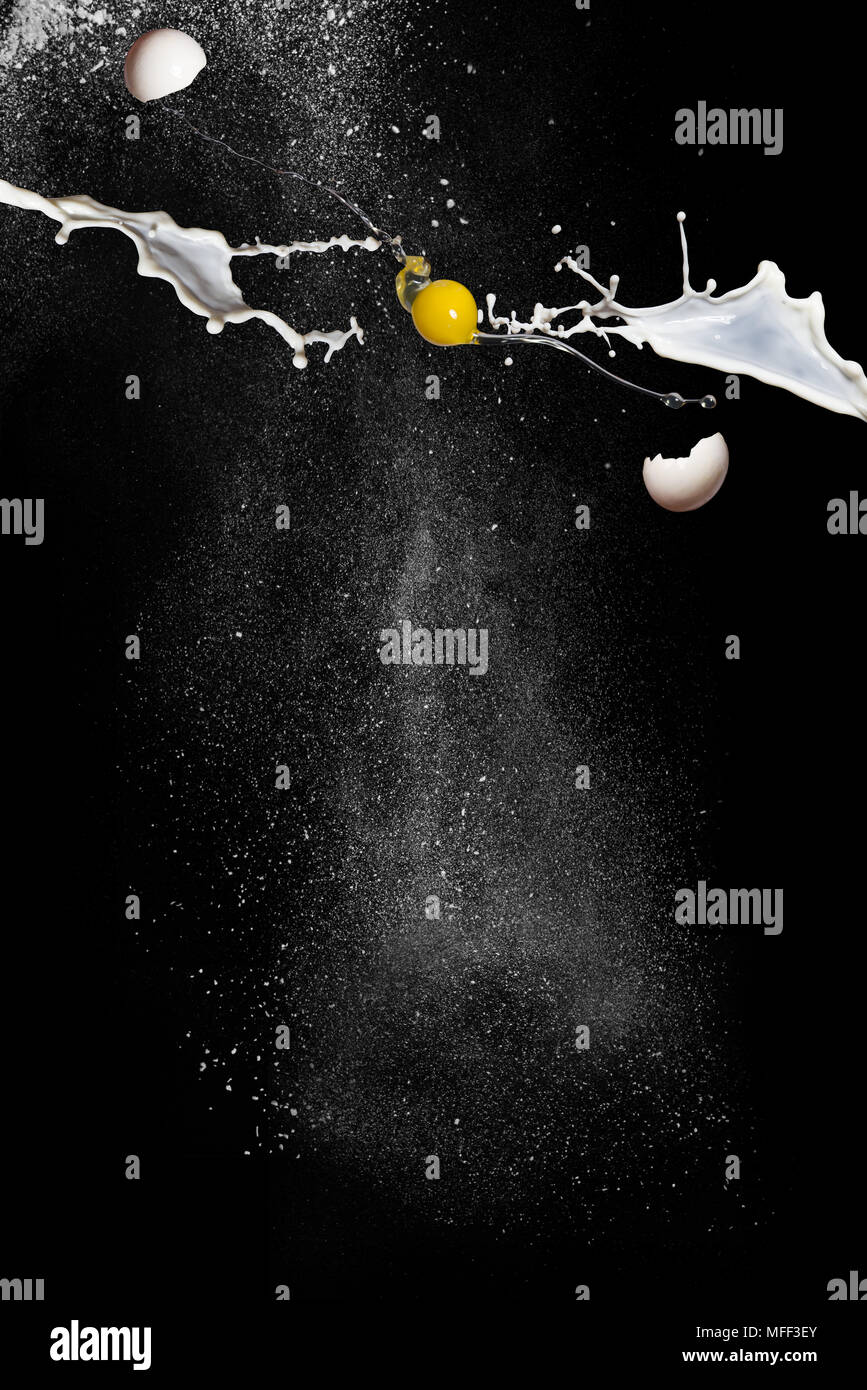 Cook breakfast. Egg in flight, milk and flour on black background ...