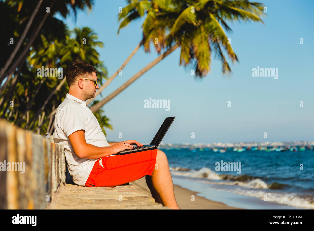Person on laptop on beach hi-res stock photography and images - Alamy