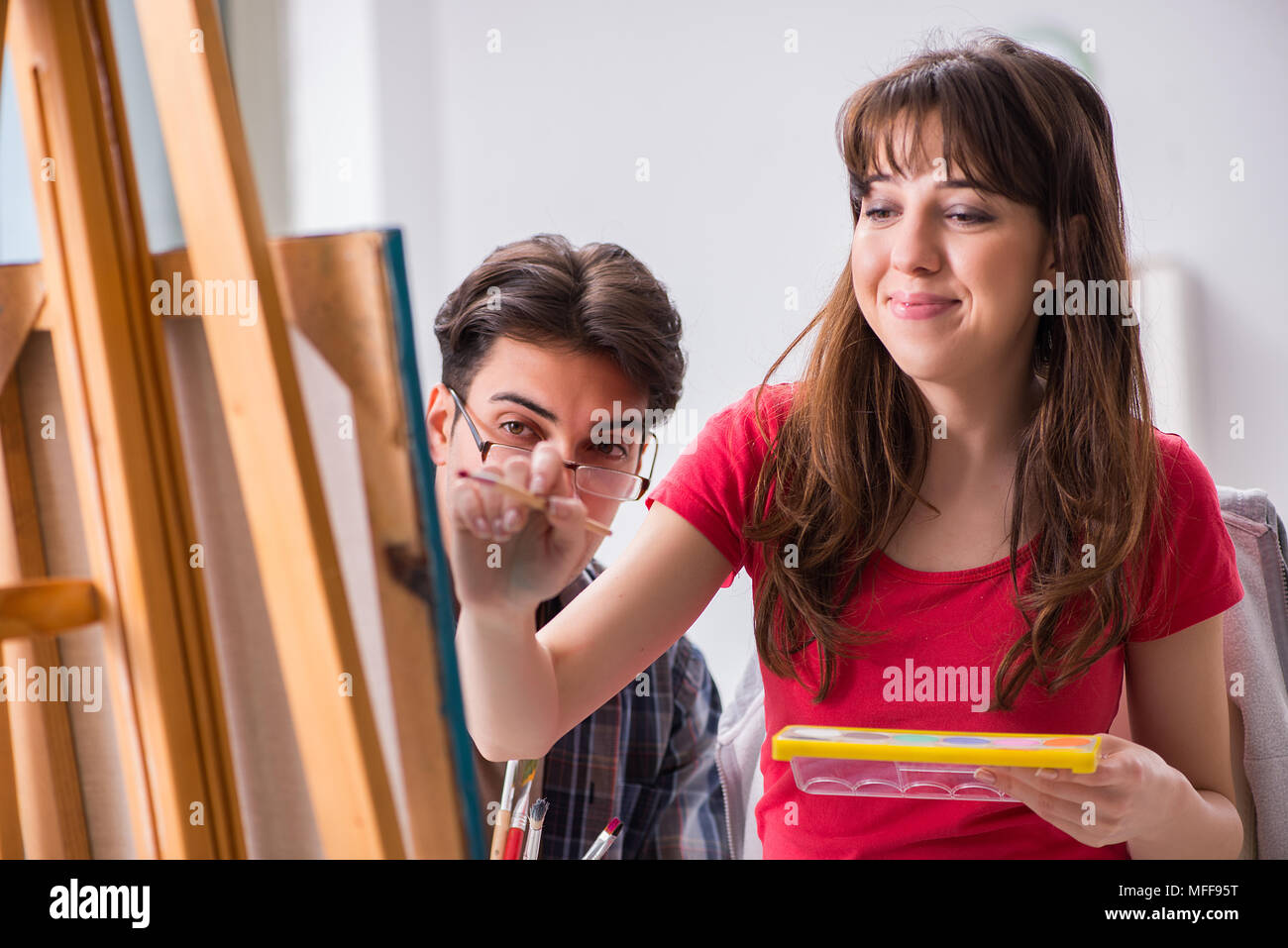 Artist coaching student in painting class in studio Stock Photo - Alamy