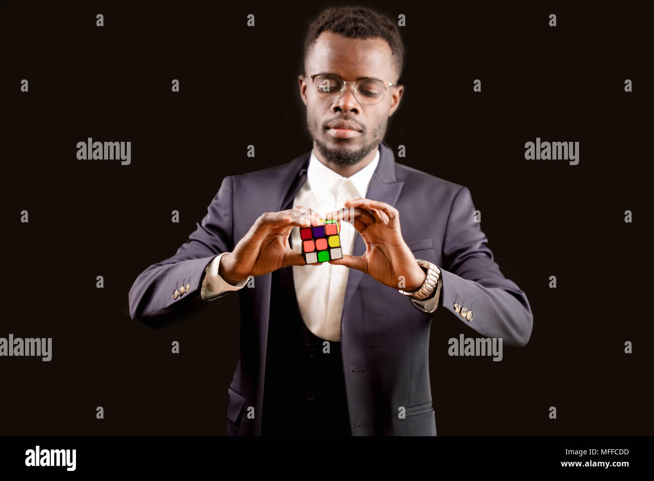 close up portrait of black man in formal clothing playing a puzzle to ...