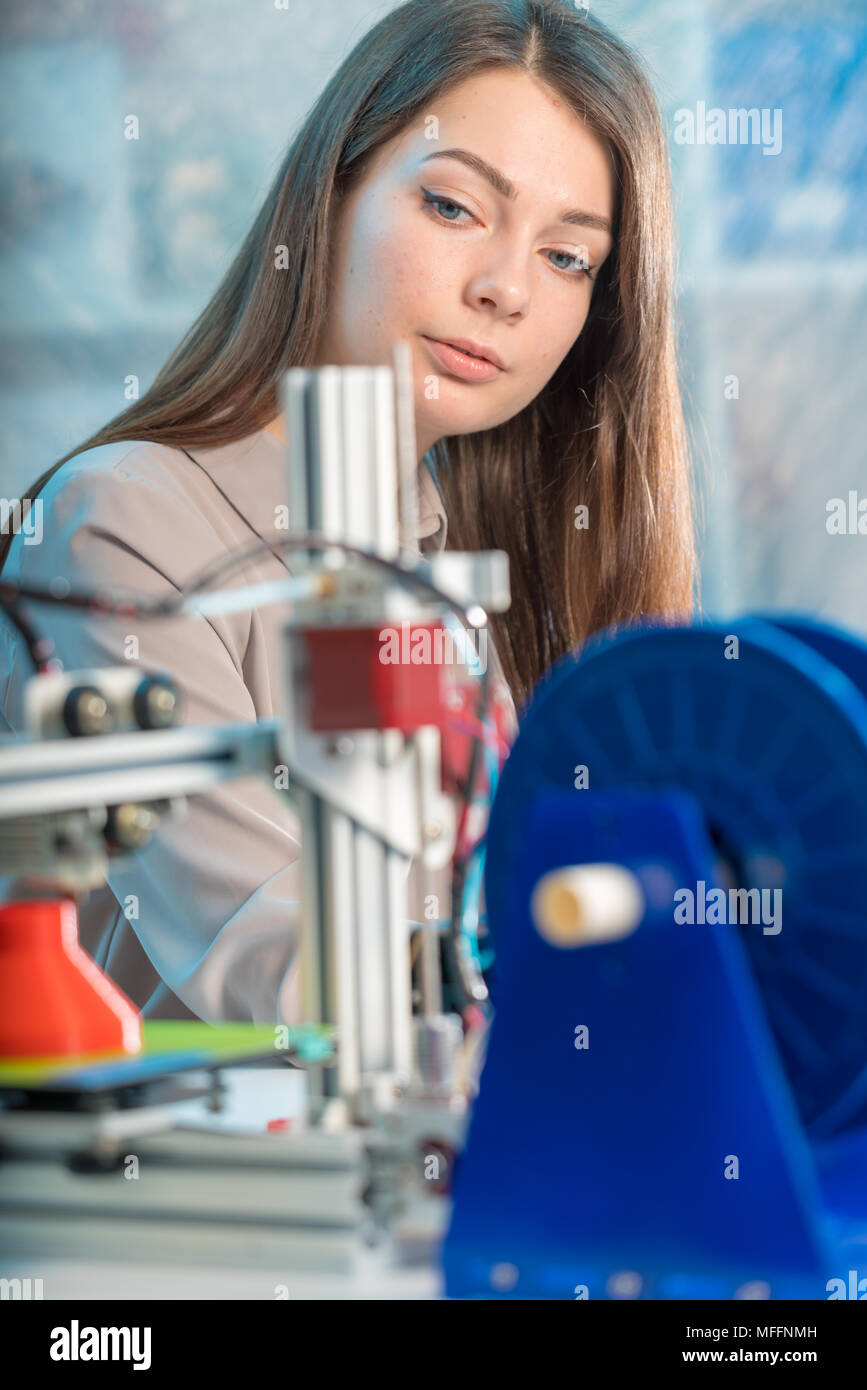 A young woman design a model of an artificial organ on a 3D printer ...