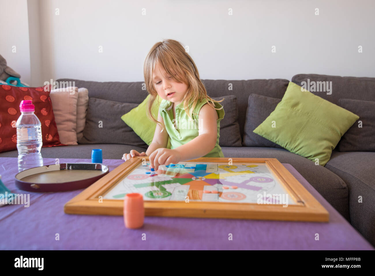 four years old blonde child with green sleeveless shirt sitting on ...