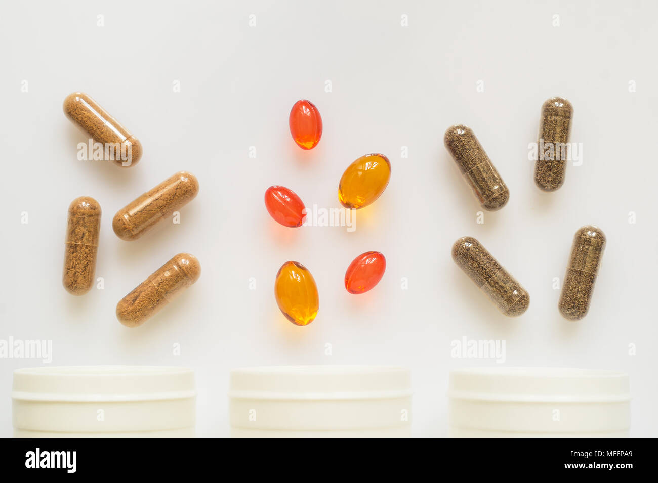 Medicinal capsule spill out of a three plastic bottles on a light ...