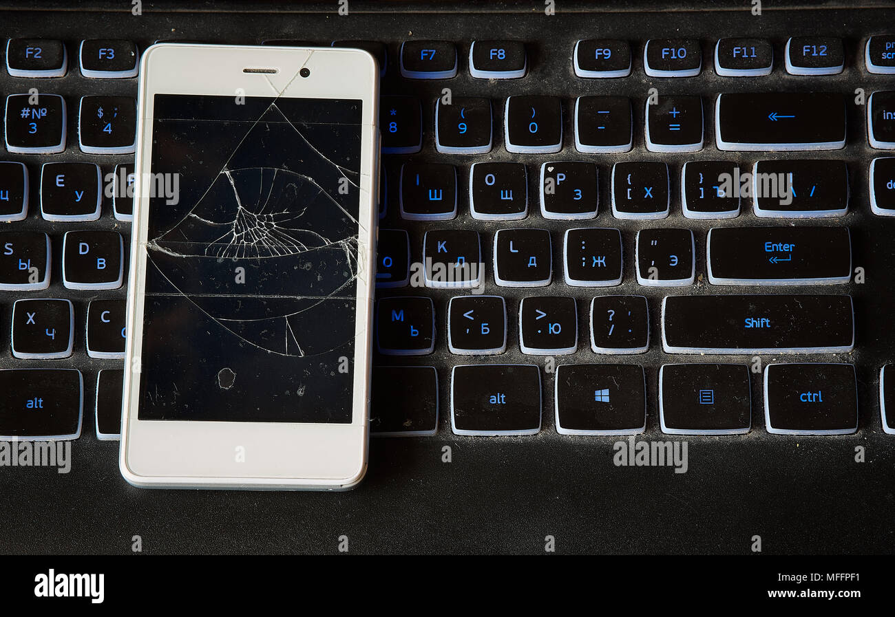 smartphone with broken screen on the background of the old backlit ...