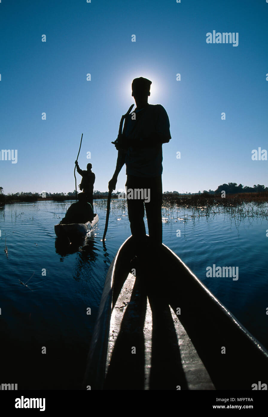 BAYEI TRIBES PEOPLE in mokoros silhouetted Okavango Delta, Botswana ...