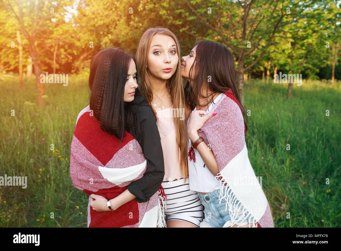 Three cute girls standing in the plaid outdoors, best friends having ...