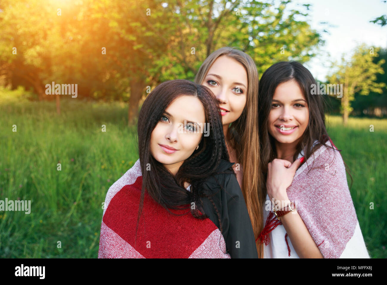 Three cute girls standing in the plaid outdoors, best friends having ...