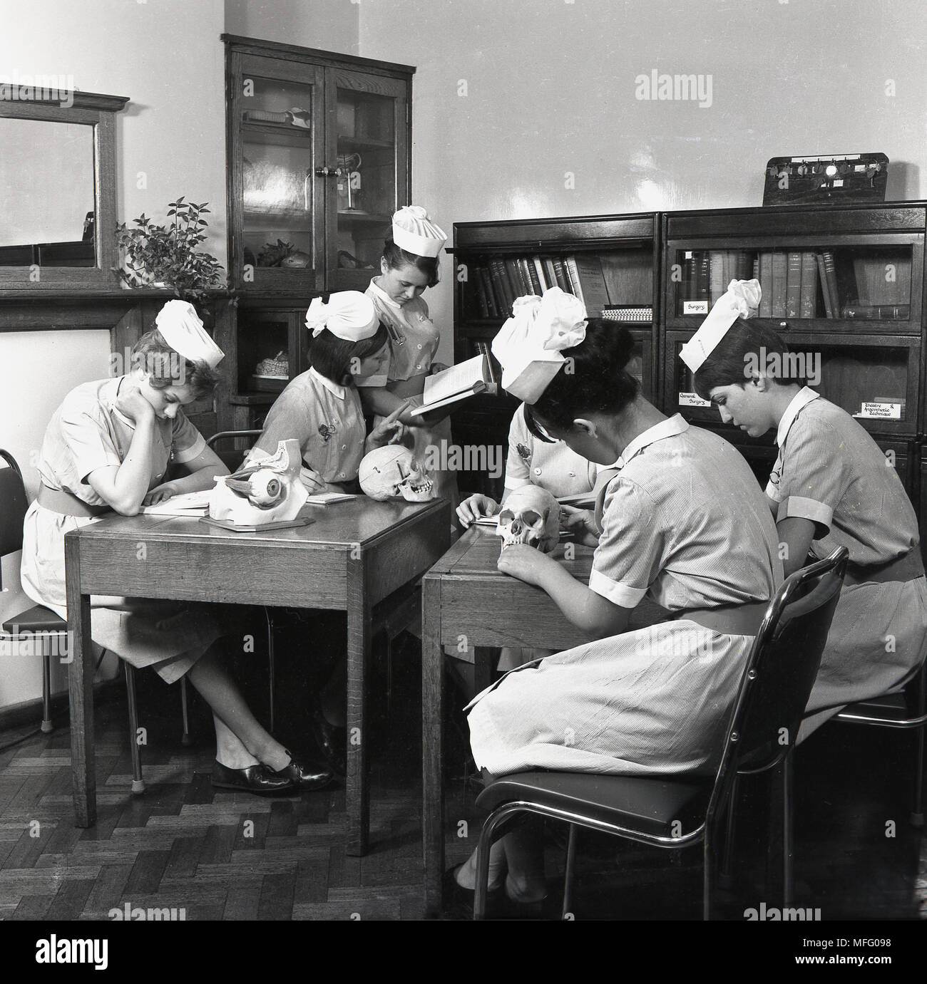 1960s, historical, young female nurses sitting together in a library ...
