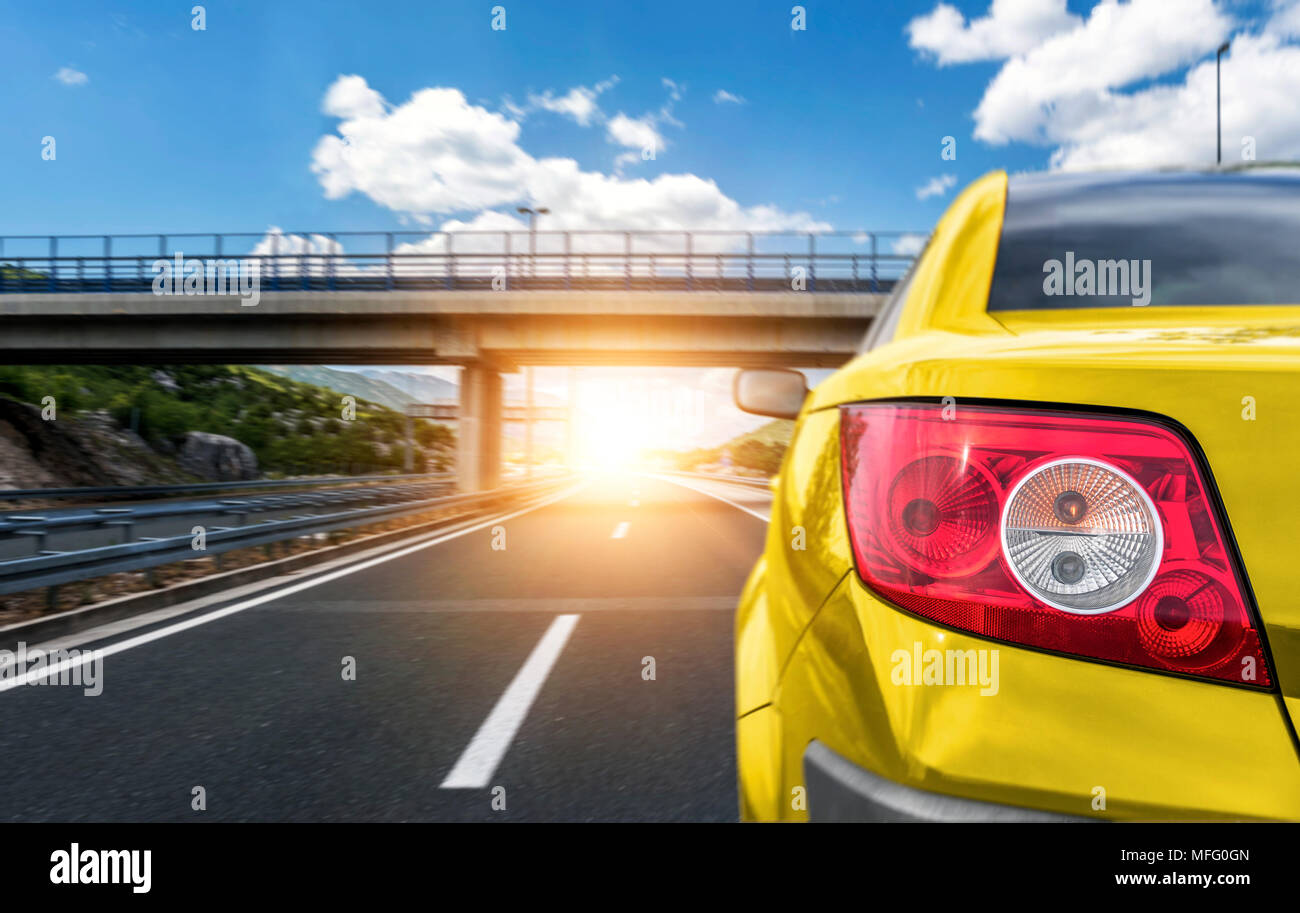 Yellow car rushing along a high-speed highway Stock Photo - Alamy