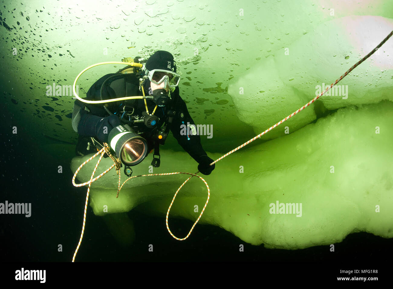 Scuba diver under ice and ice formation, Arctic circle Dive Center ...