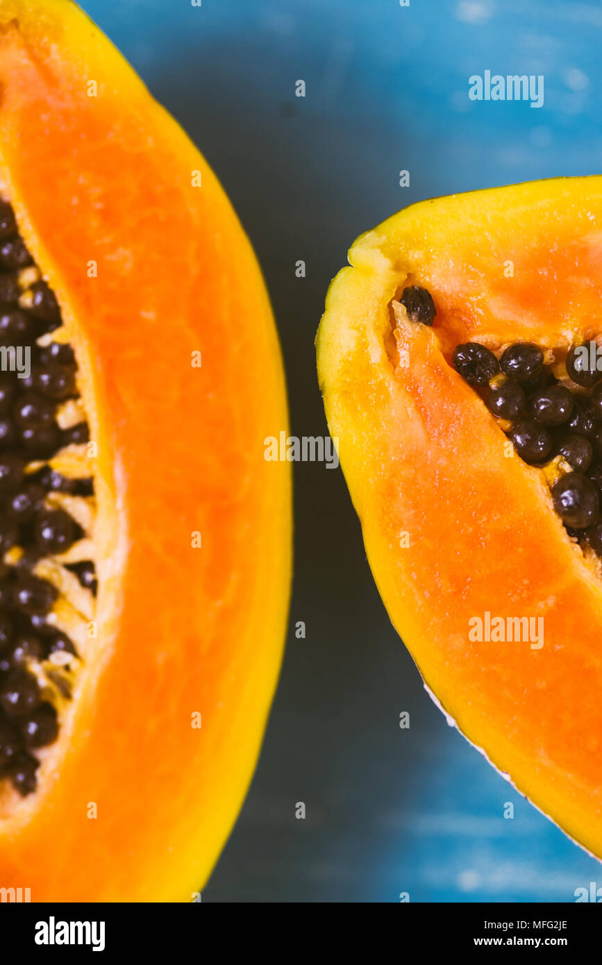 Close up of tropical fruit papaya cut i half on a wooden background ...