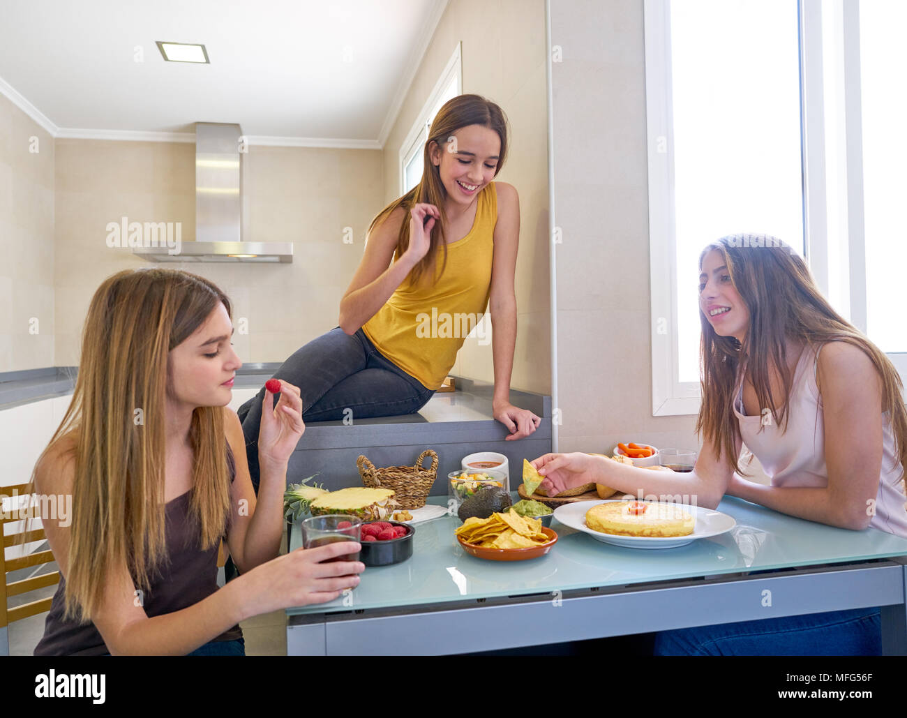 teen girls best friends having lunch eating at kitchen table having fun ...