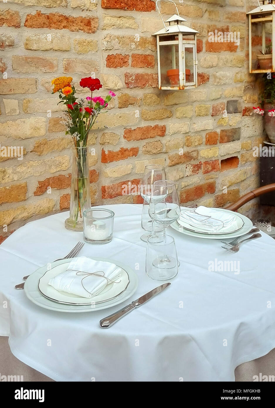 White table set with a colorful flower pot on it and a raw wall Stock ...