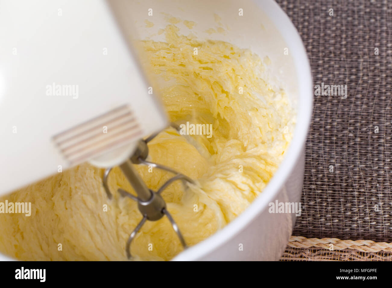 Mixing butter and eggs in white bowl with motor mixer. Photo can be ...