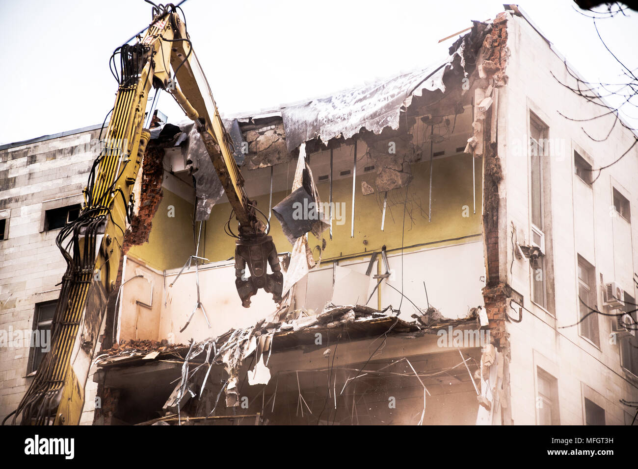 mechanical destruction. Demolition crane dismantling a concrete ...