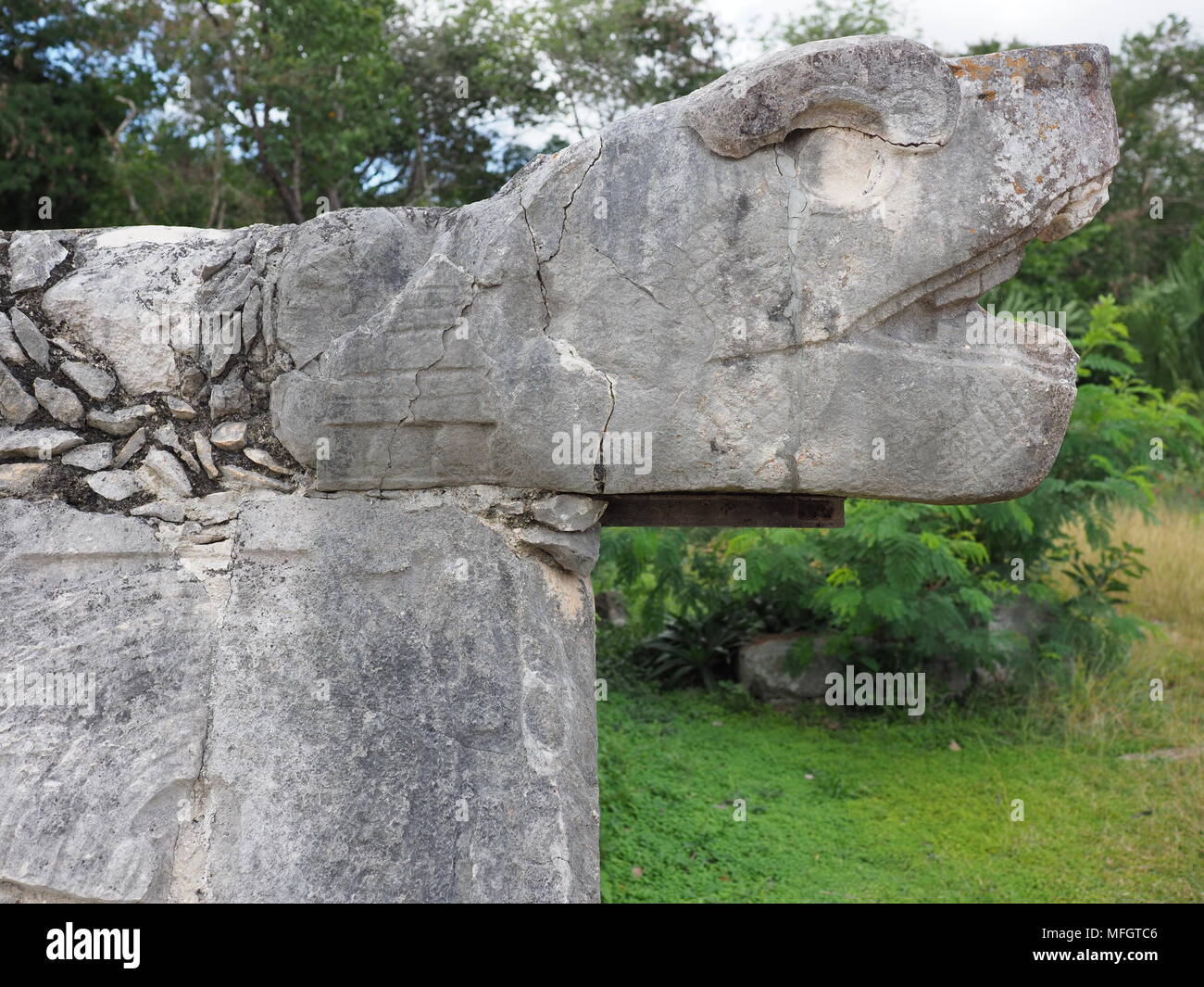 Sculpted stony snake head at mayan ruins of great ball court building ...