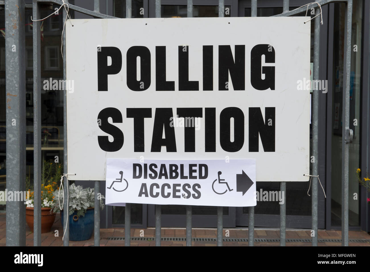 British election polling station sign hanging on post next to a gate ...