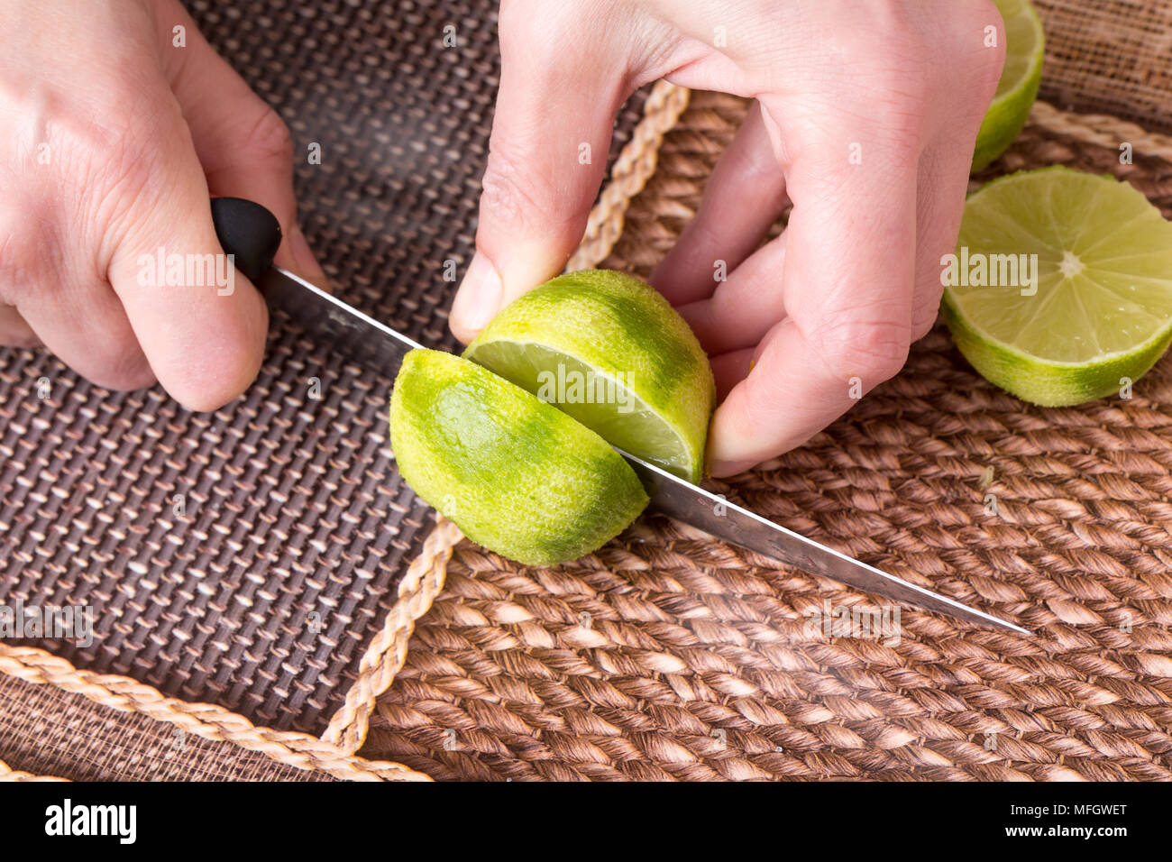 Slicing zested lime with knife on a table as a background Stock Photo ...