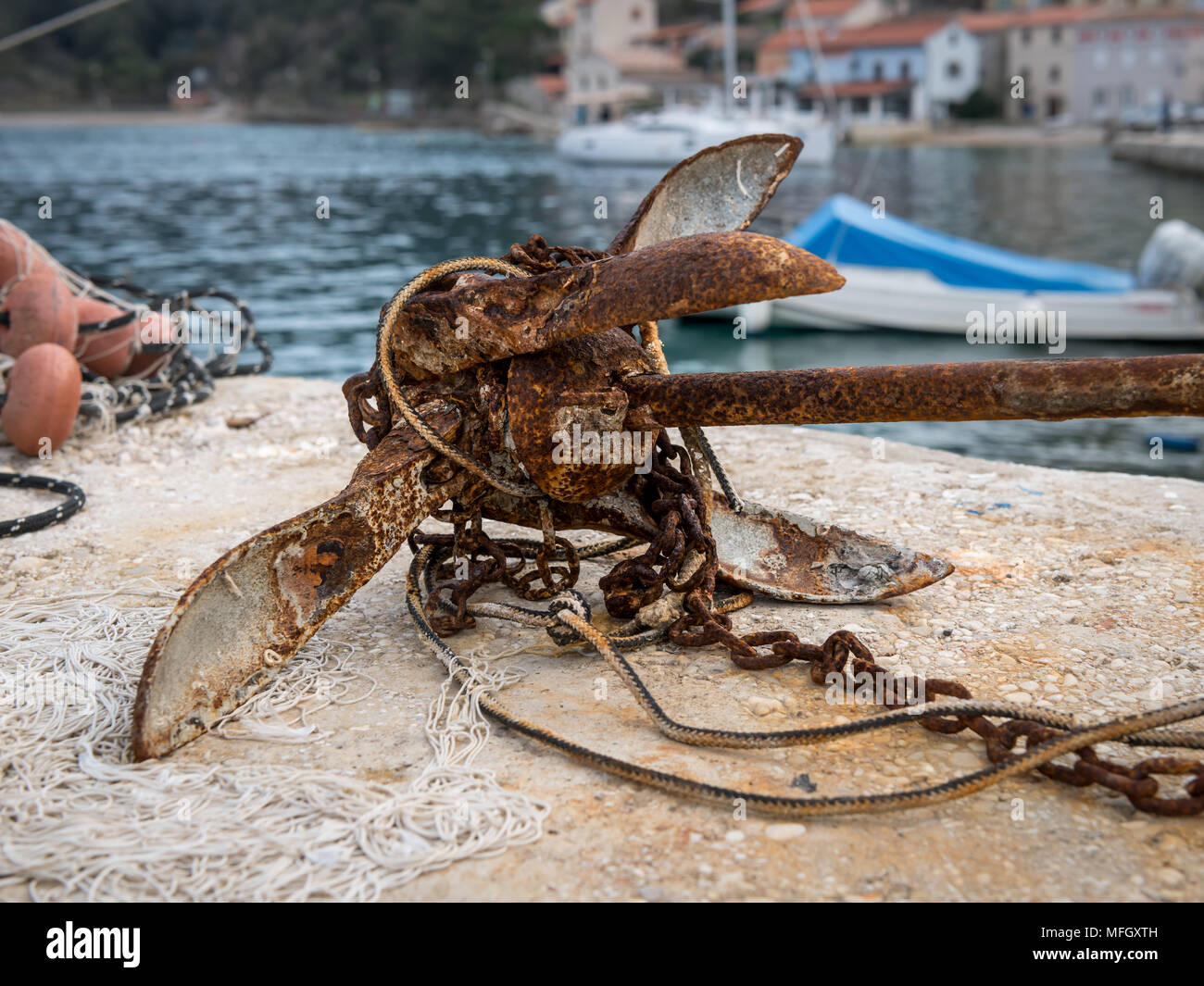 Small rusty anchor with chain lying on the ground, Croatia Stock Photo ...