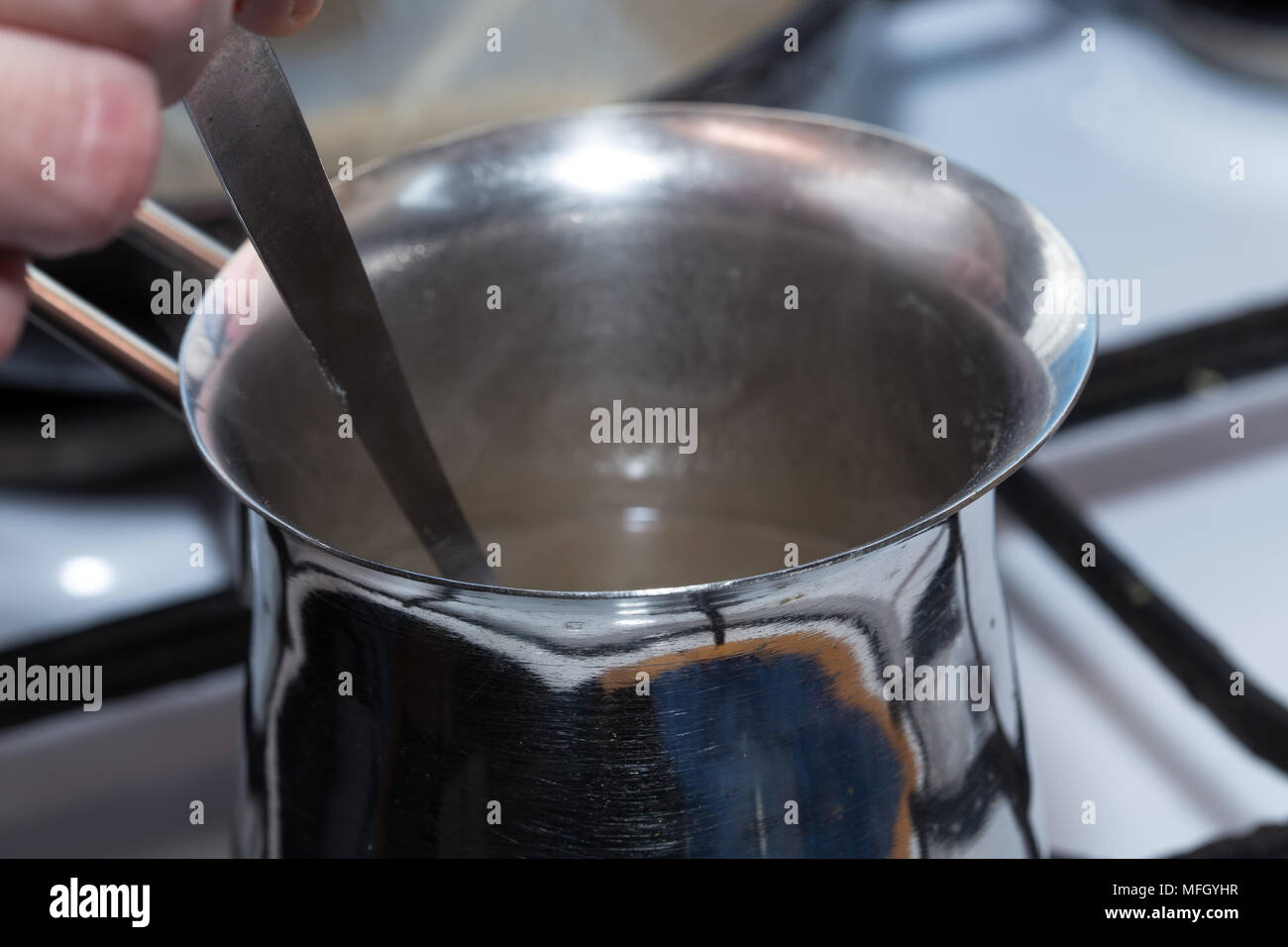 Melted gelatin in metal pot on the stove. Macro. Photo can be used as a ...