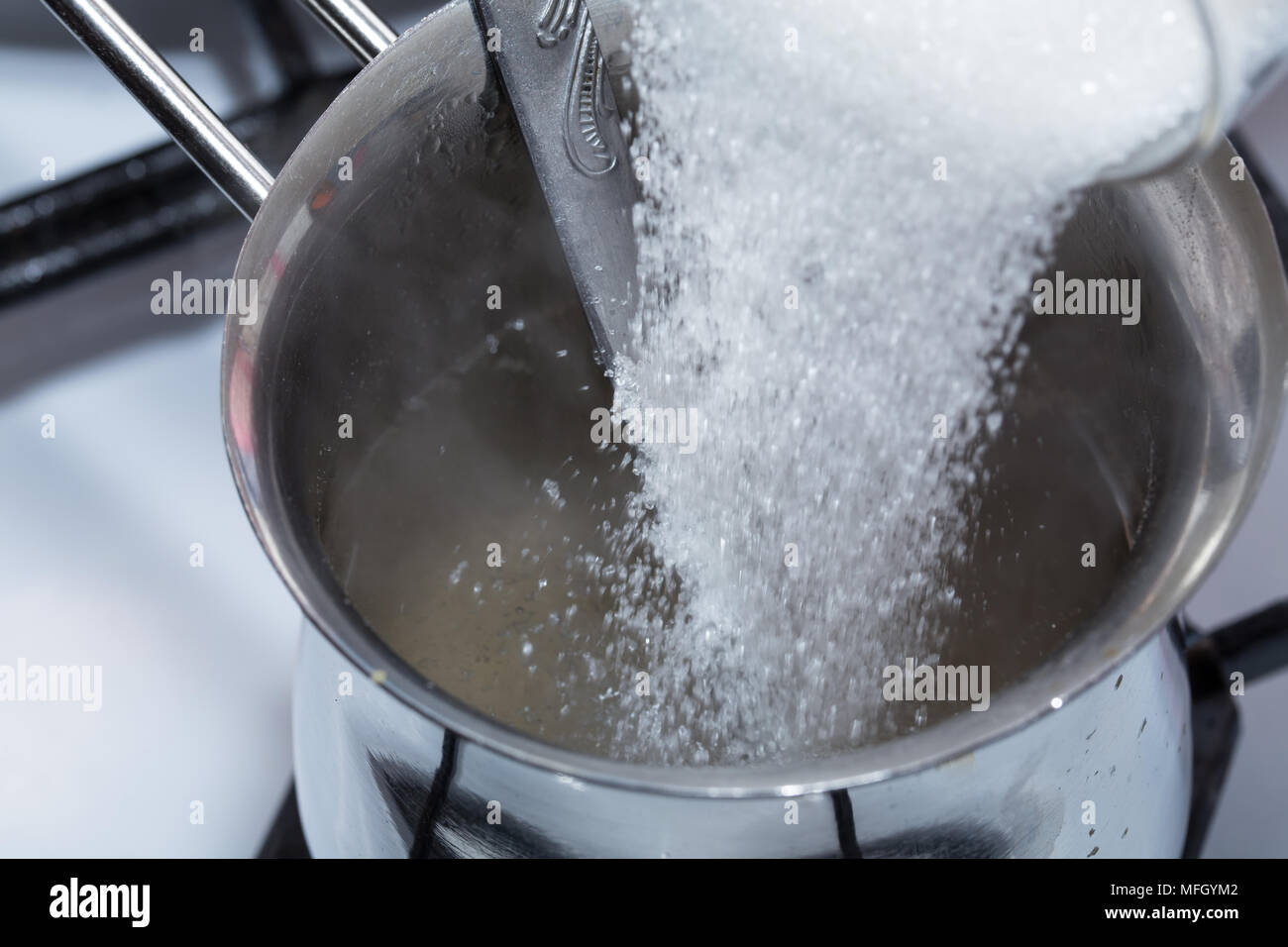 Mixing sugar and melted gelatin in metal pot on the stove. Macro. Photo ...