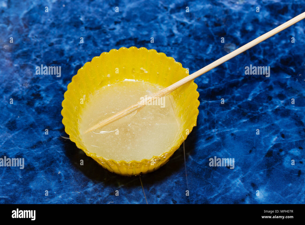 Melted sugar in plastic form closeup on blue table. Macro. Photo can be ...