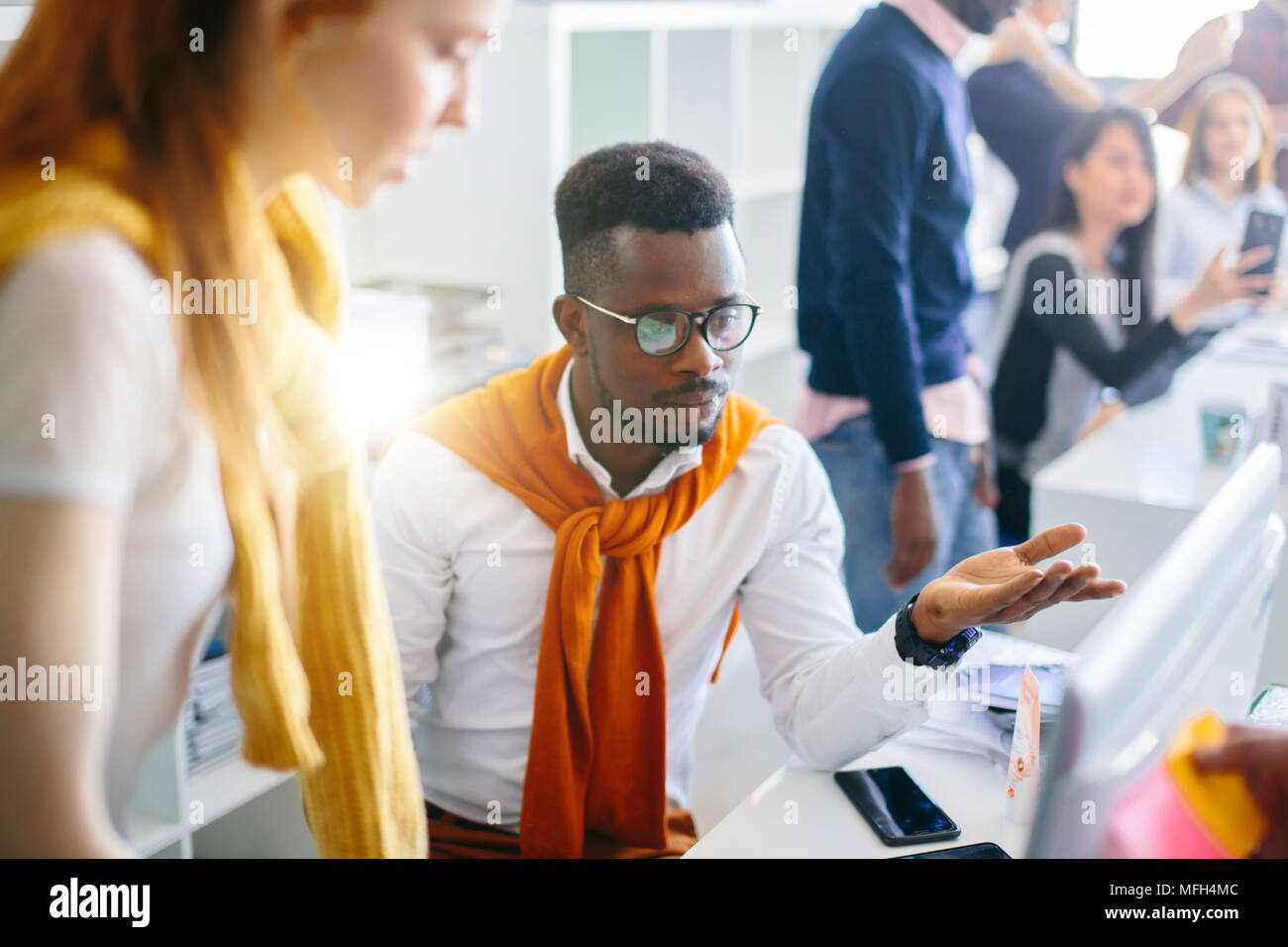 close up shot of sad young black man showing computer to ginger woman ...