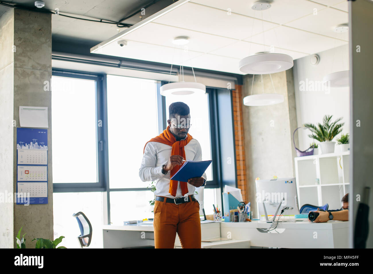 young black man using the blue folder at work Stock Photo - Alamy