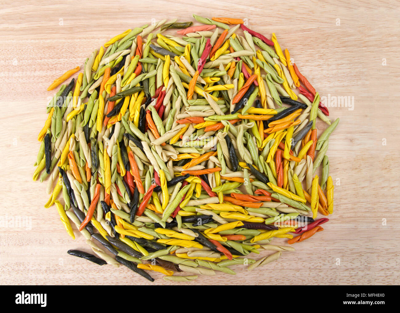 Pile of bright colorful hand rolled dry pasta made from vegetables on a ...