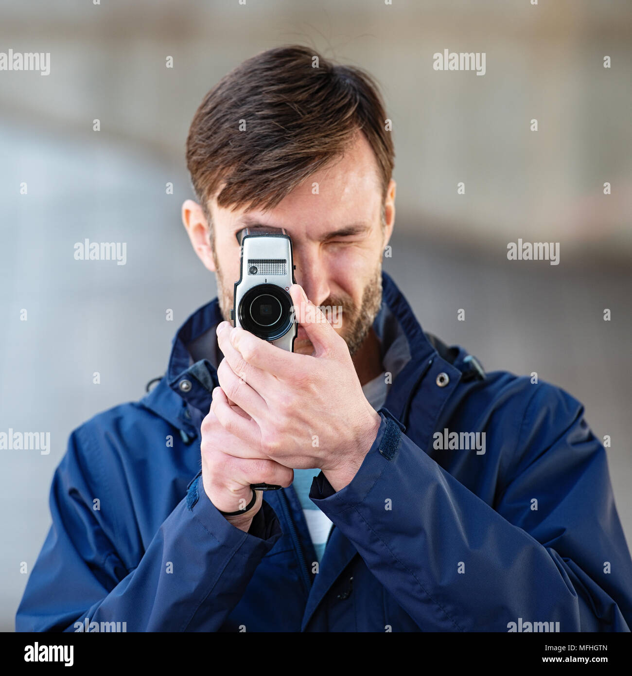 bearded man professional cameraman observes and shoots an 8mm movie ...