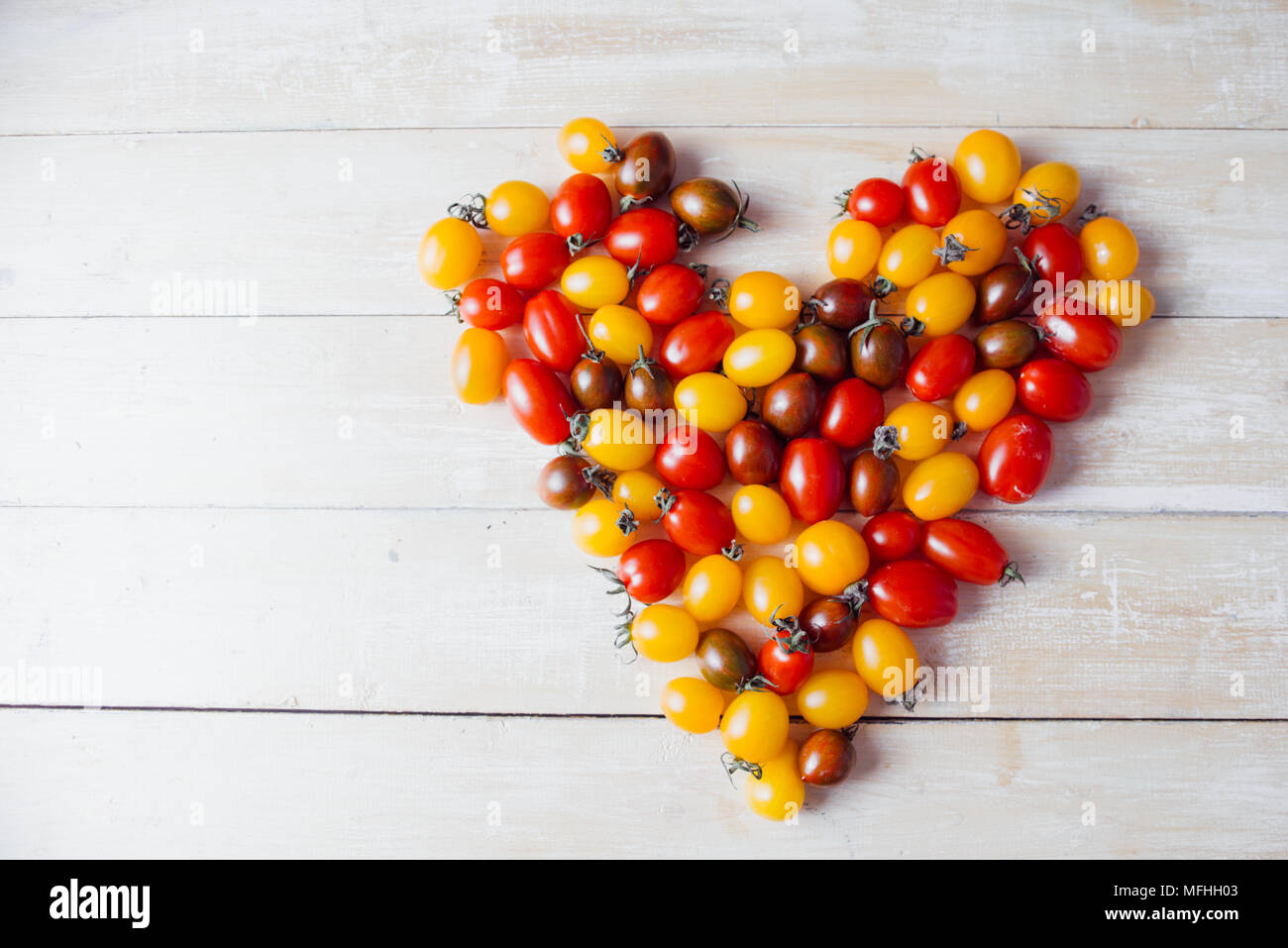 Freshly washed mixed cherry tomatoes displayed forming an heart shape ...