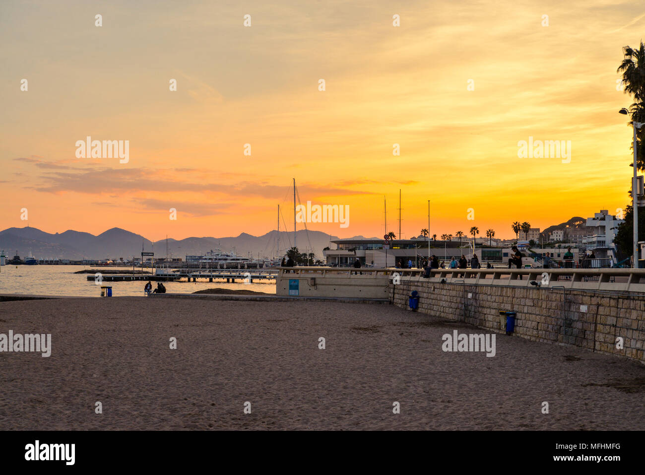 Tourists relaxing on the beach in Cannes at sunset Stock Photo - Alamy