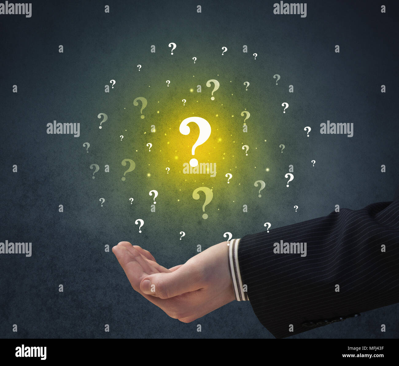 Yellow question marks hovering over young hand Stock Photo - Alamy