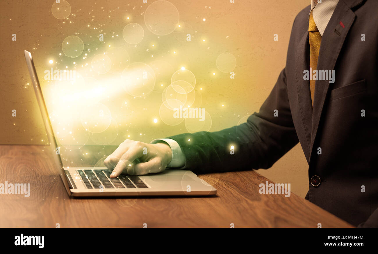 An elegant businessman sitting at desk and pushing the buttons of his ...