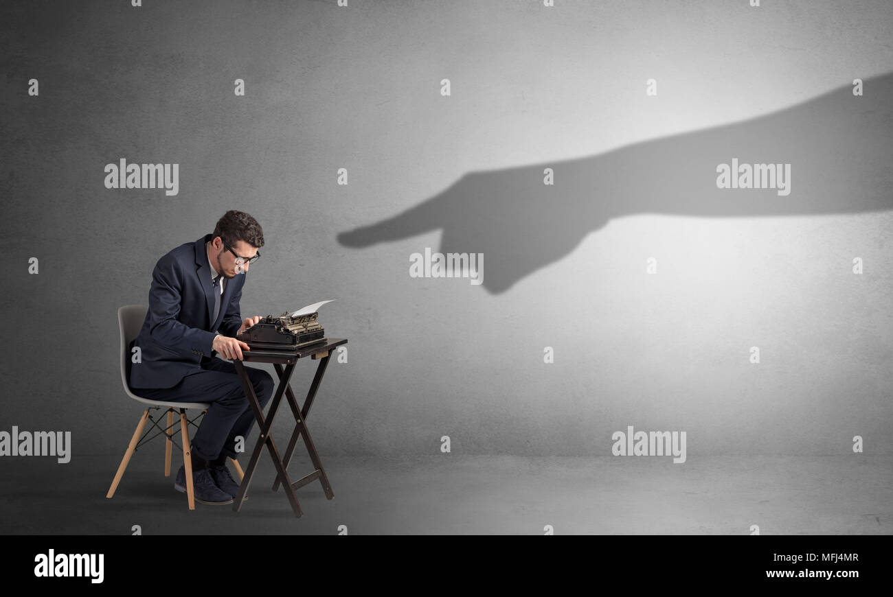 Shadow hand pointing at a small afraid worker Stock Photo - Alamy
