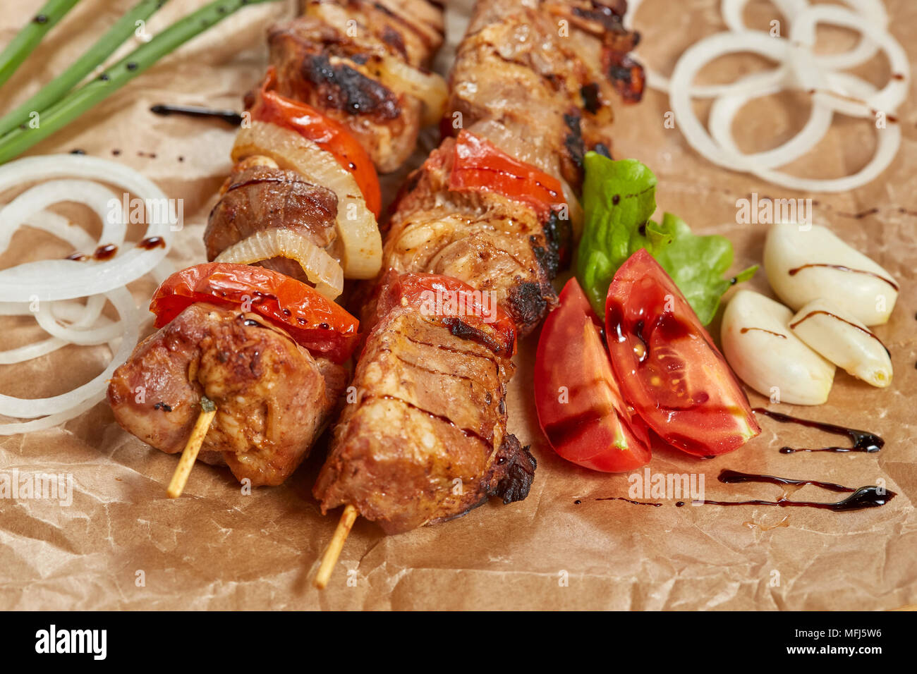 Pork meat kebab with sauces and vegetables on paper Stock Photo - Alamy