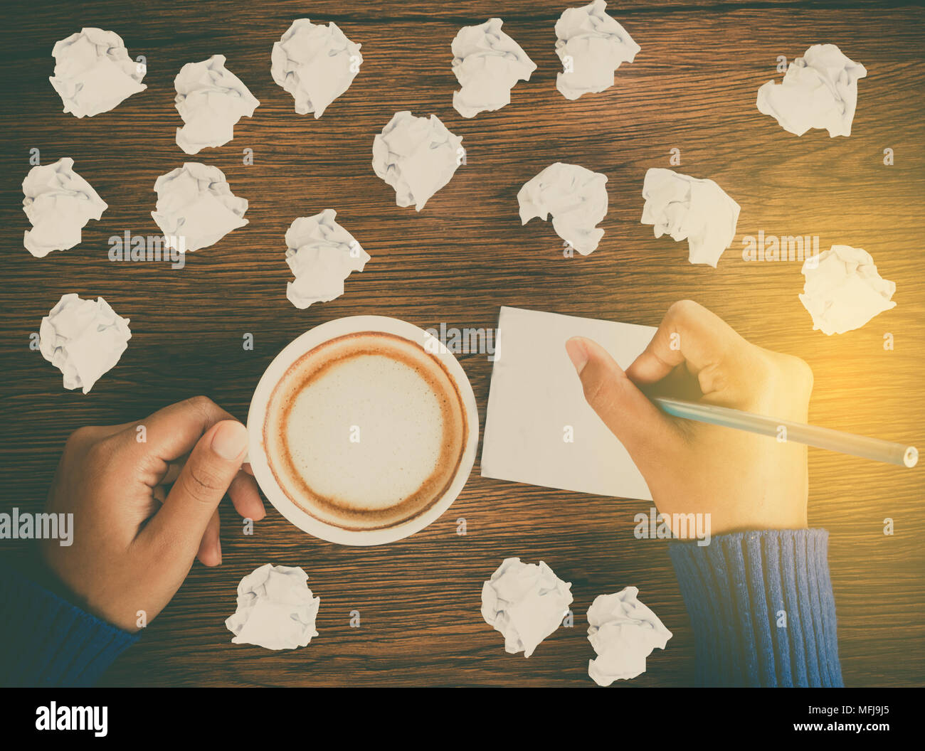 Human hand writing something with cup of coffee and crumpled paper ...