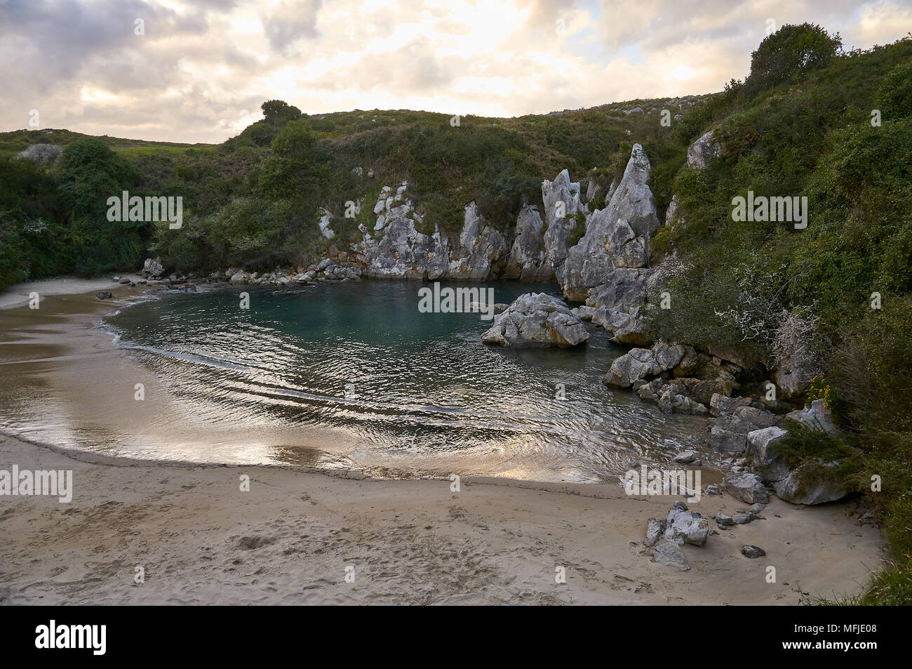 Sunset at Gulpiyuri beach, which is an inland beach arose in flooded ...